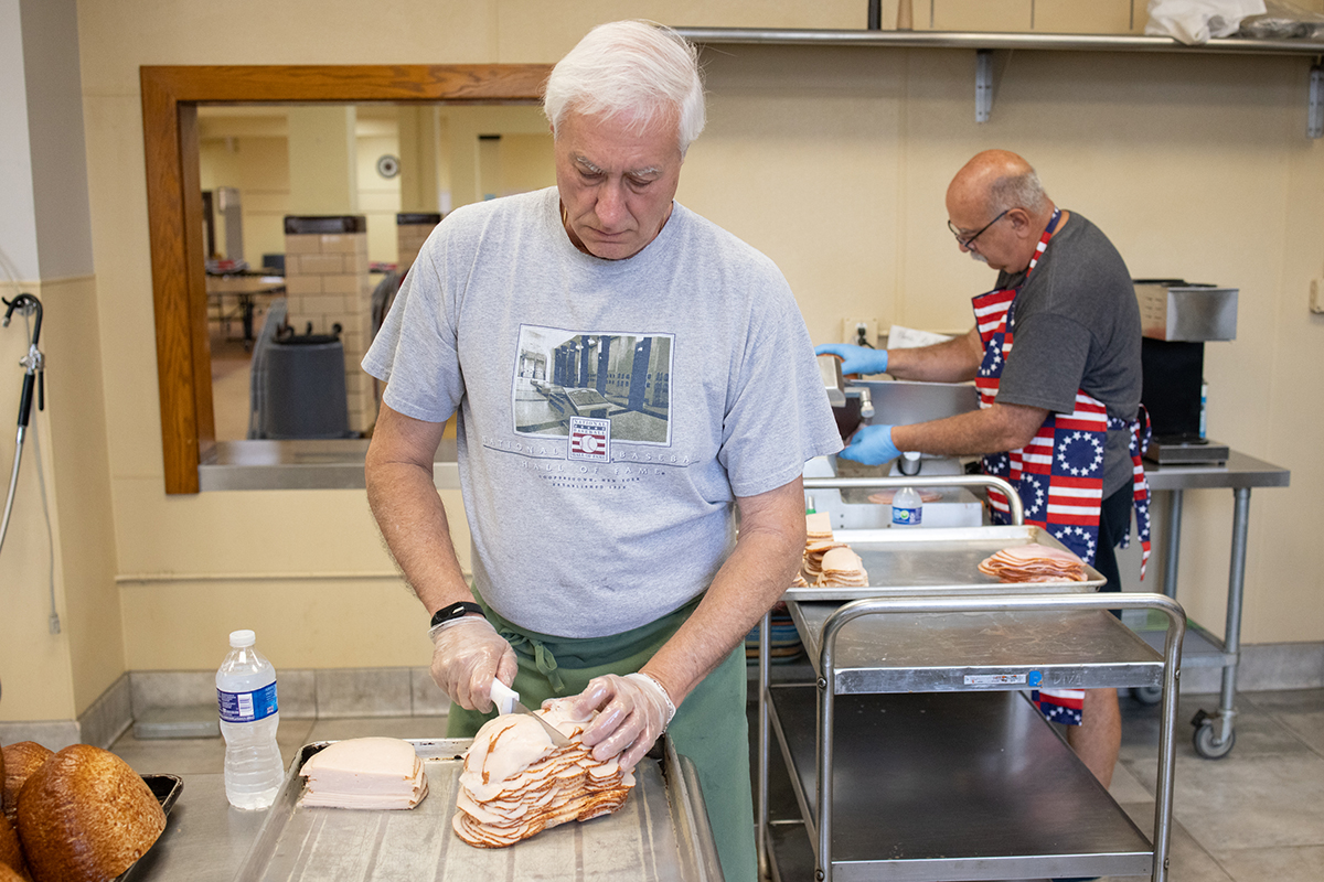 Volunteers with the St. Ambrose Society put hands, feet to work in ...
